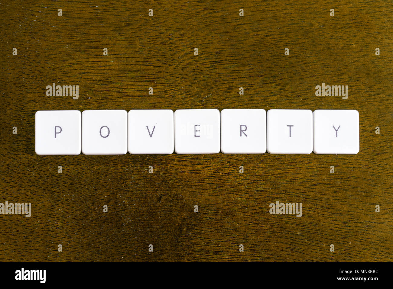 POVERTY word written on plastic keyboard alphabet with dark background ...