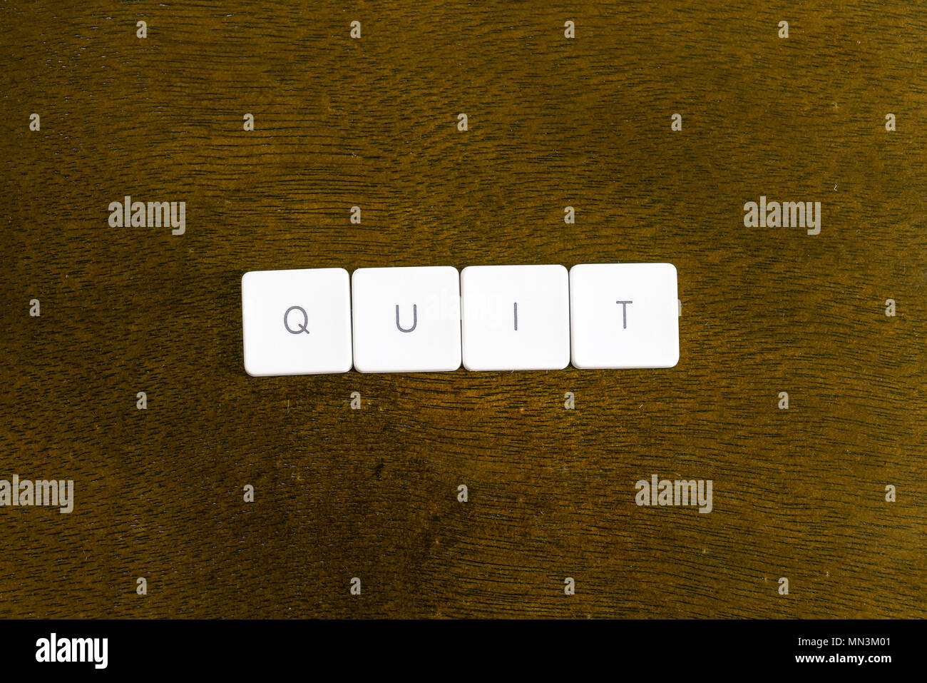 QUIT word written on plastic keyboard alphabet with dark background ...
