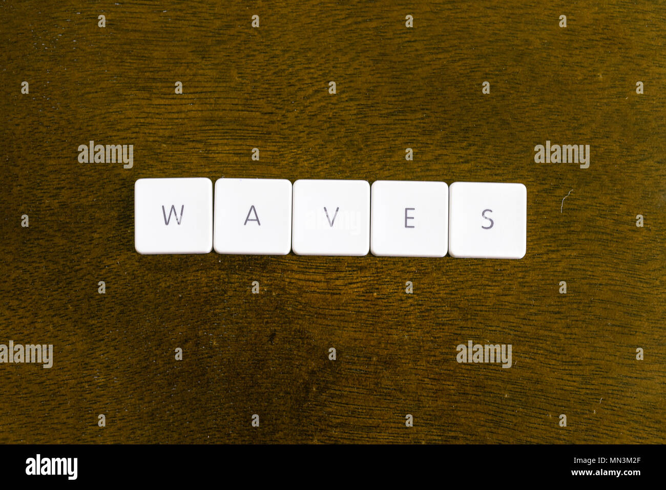 WAVES word written on plastic keyboard alphabet with dark background ...