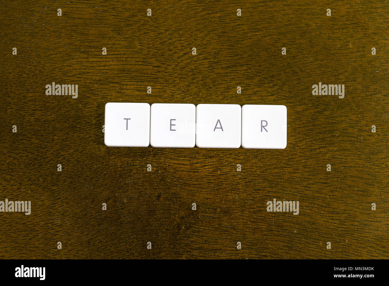TEAR word written on plastic keyboard alphabet with dark background ...