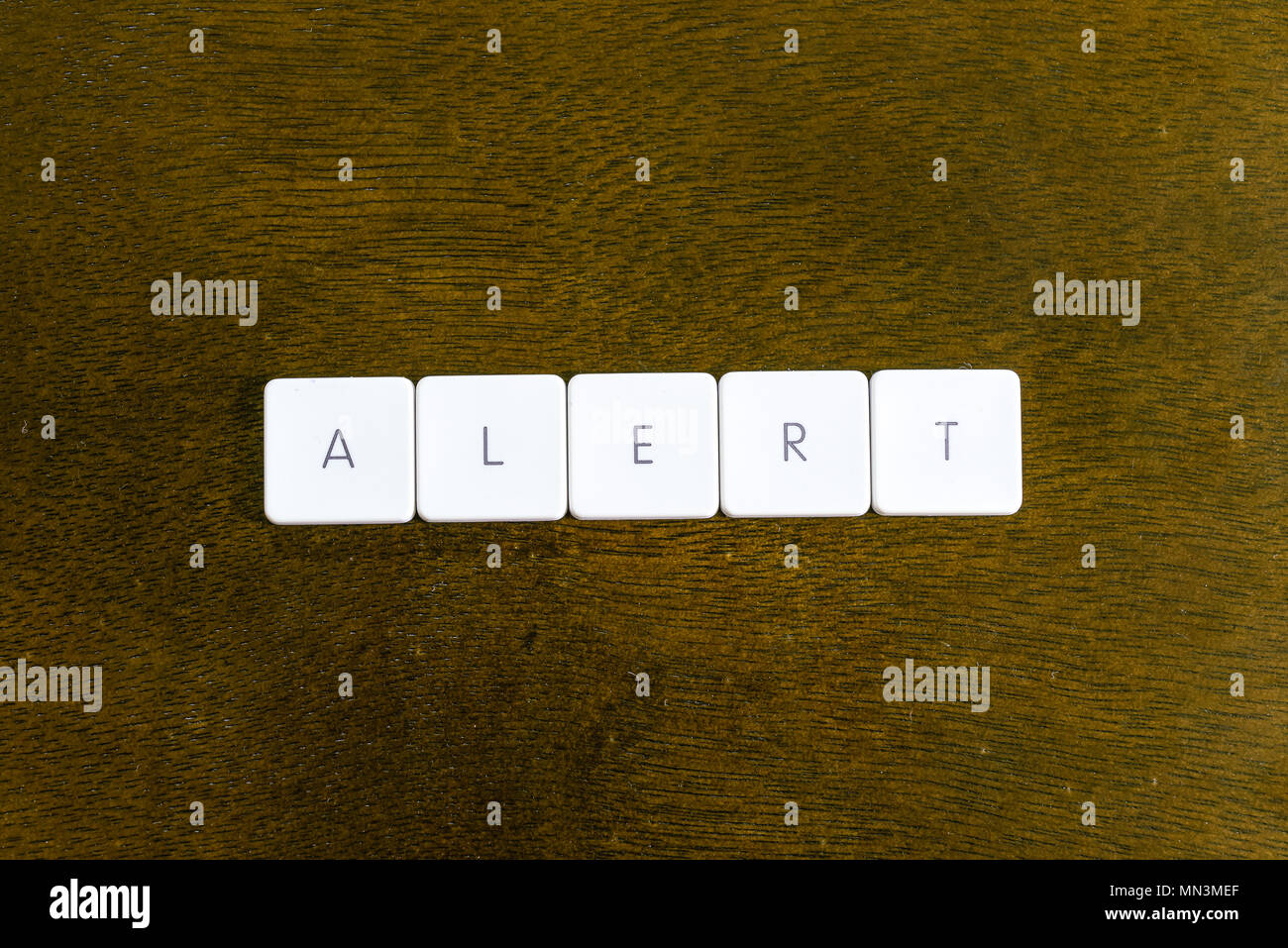 ALERT word written on plastic keyboard alphabet with dark background ...