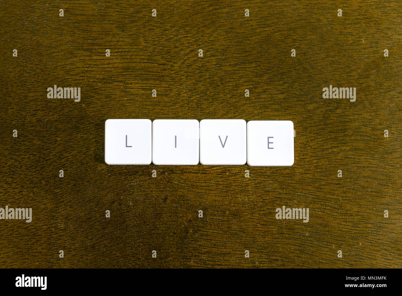 LIVE word written on plastic keyboard alphabet with dark background ...