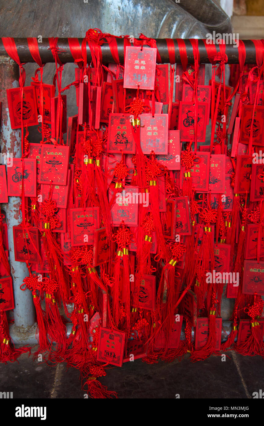 Dozens of red Chinese offering tags hanging on a railing in the Ming ...