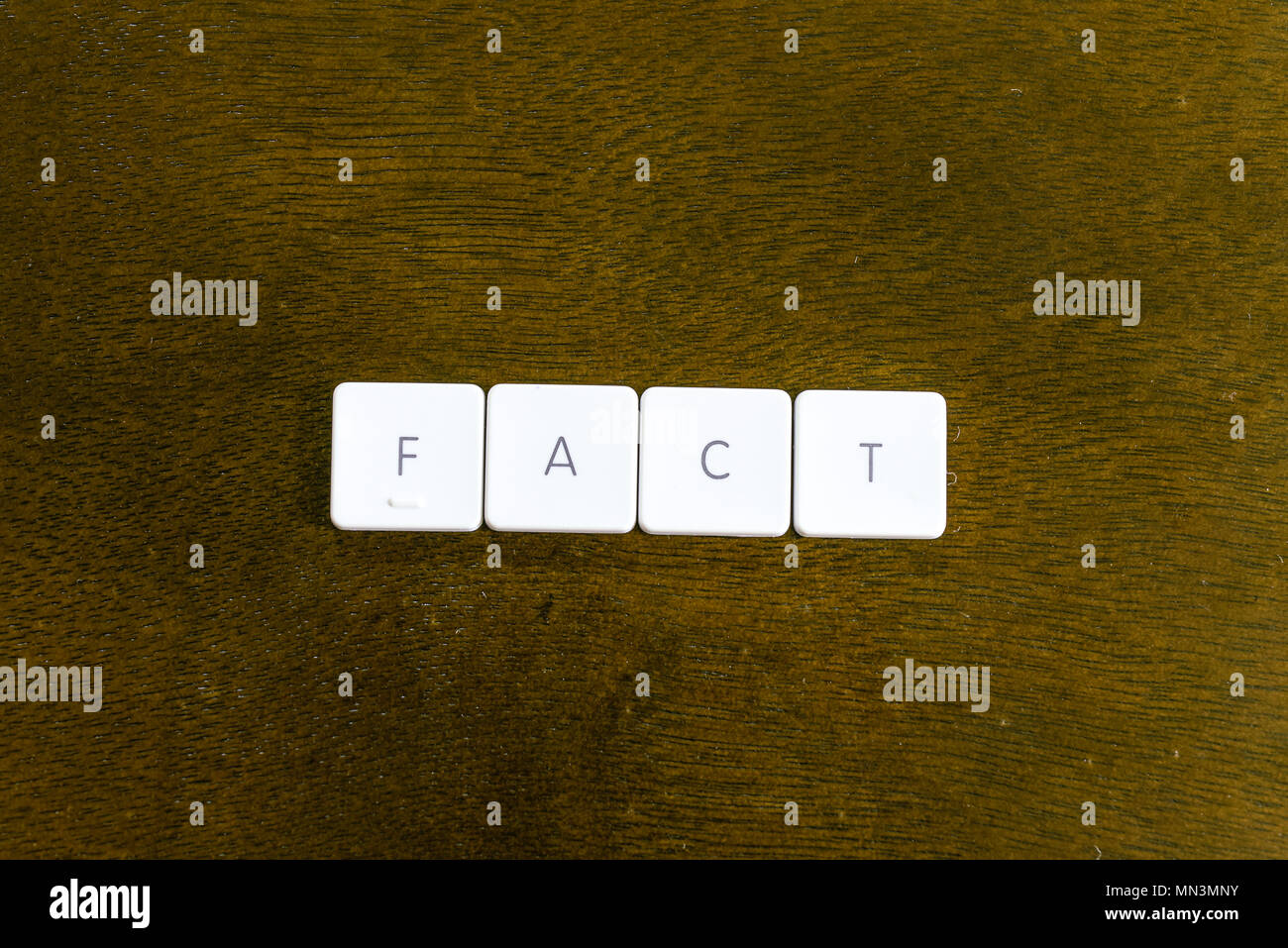 FACT word written on plastic keyboard alphabet with dark background ...