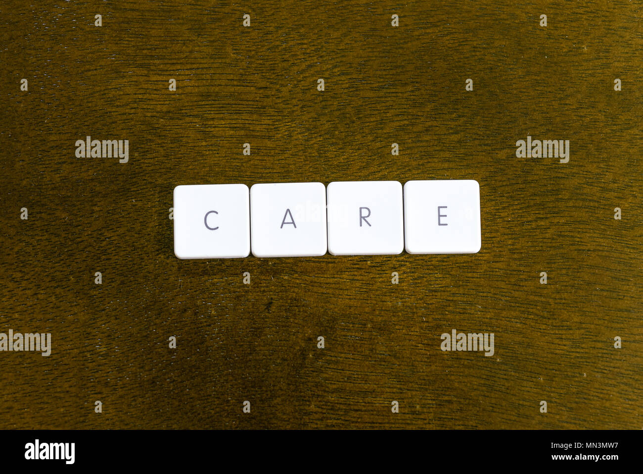 CARE word written on plastic keyboard alphabet with dark background ...