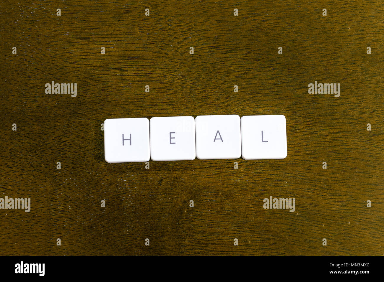 HEAL word written on plastic keyboard alphabet with dark background ...