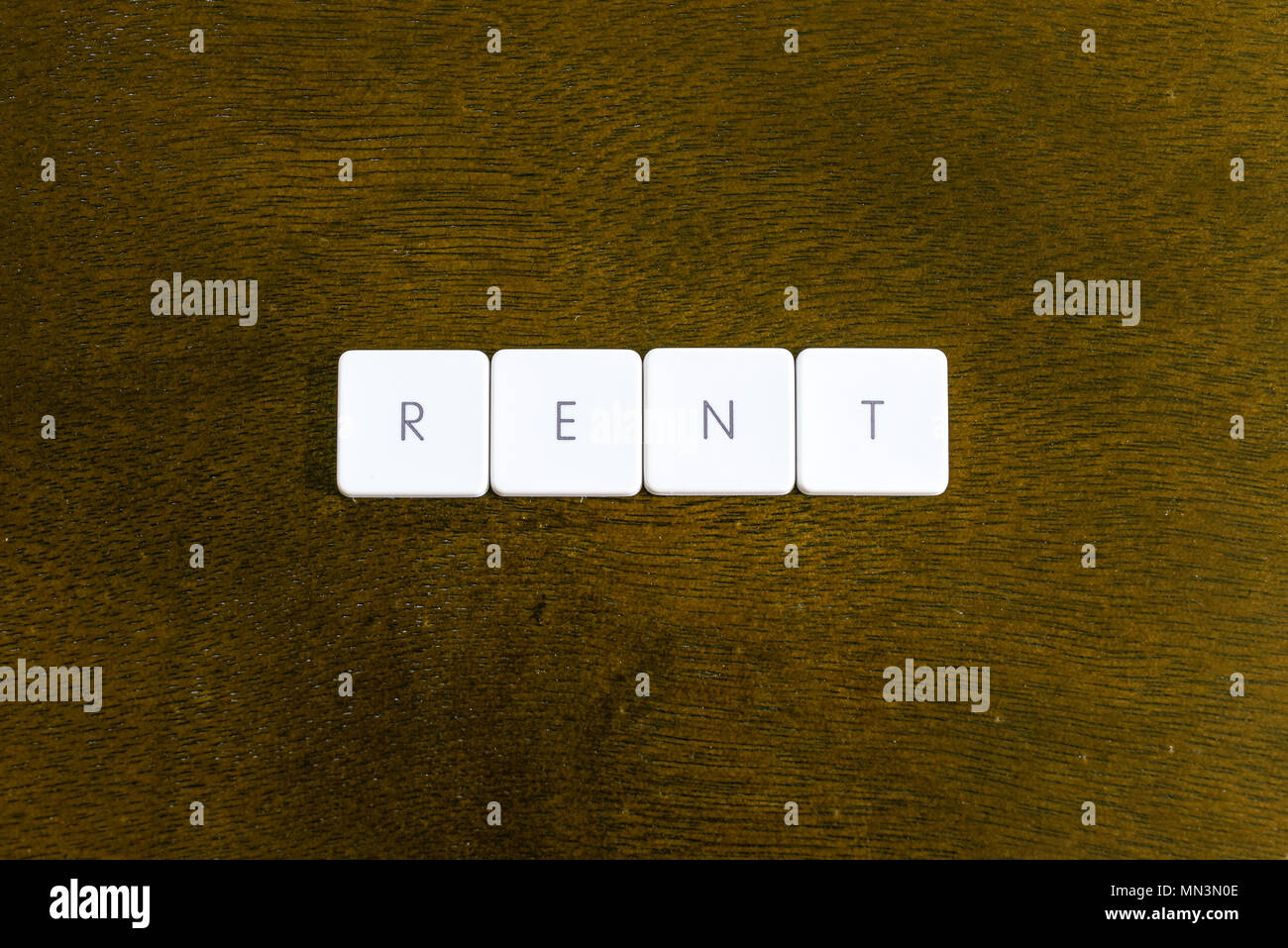 RENT word written on plastic keyboard alphabet with dark background ...