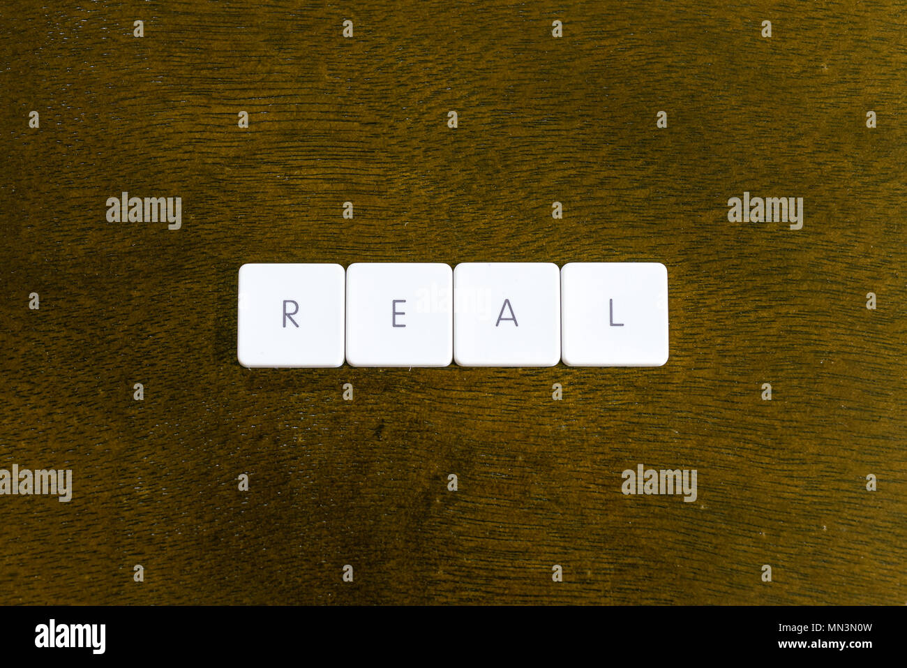 REAL word written on plastic keyboard alphabet with dark background ...