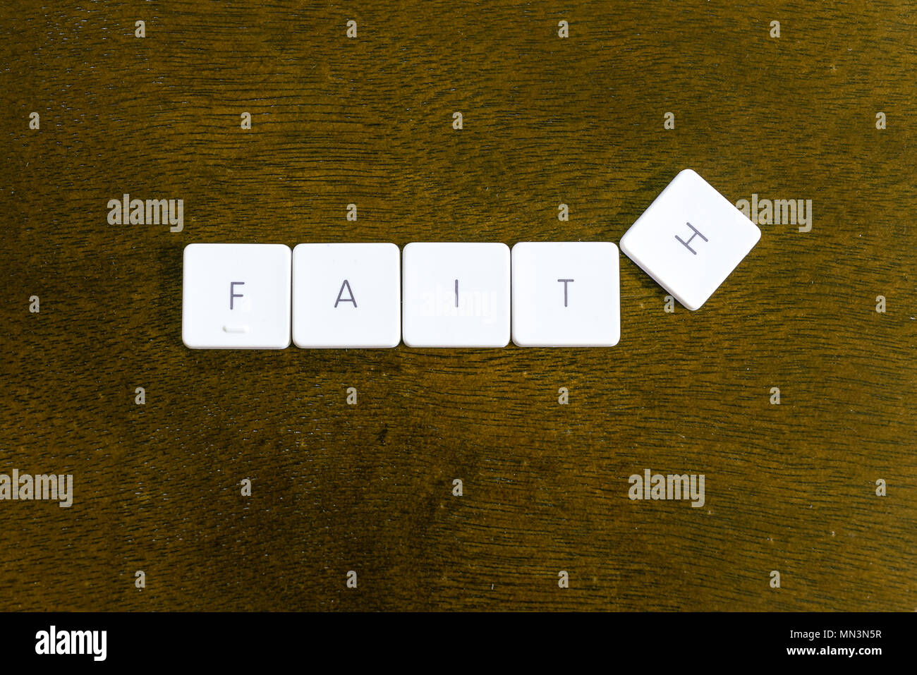 FAITH word written on plastic keyboard alphabet with dark background ...