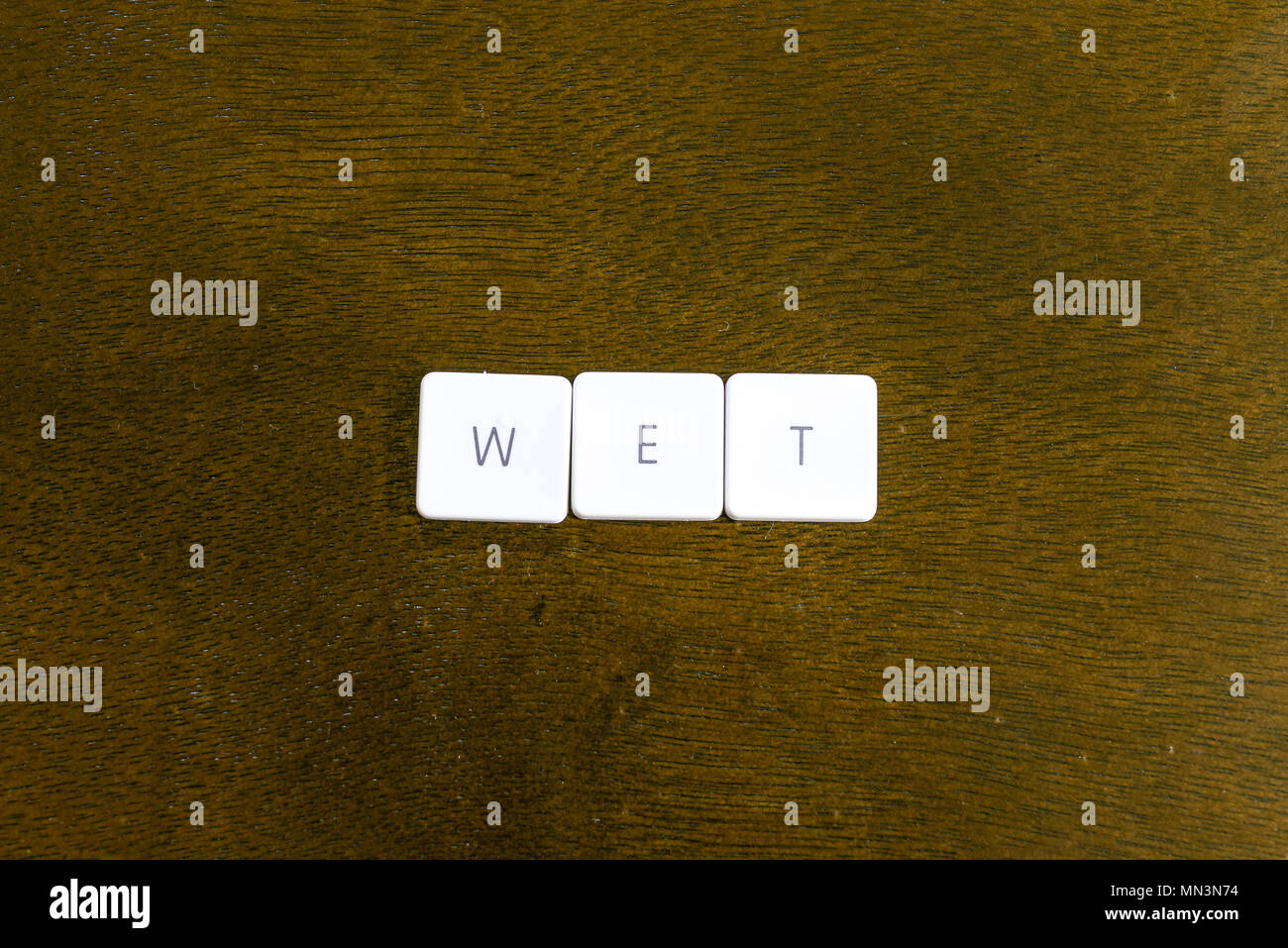 WET word written on plastic keyboard alphabet with dark background ...