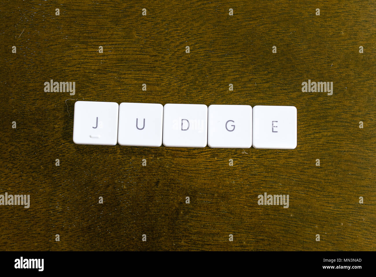 JUDGE word written on plastic keyboard alphabet with dark background ...