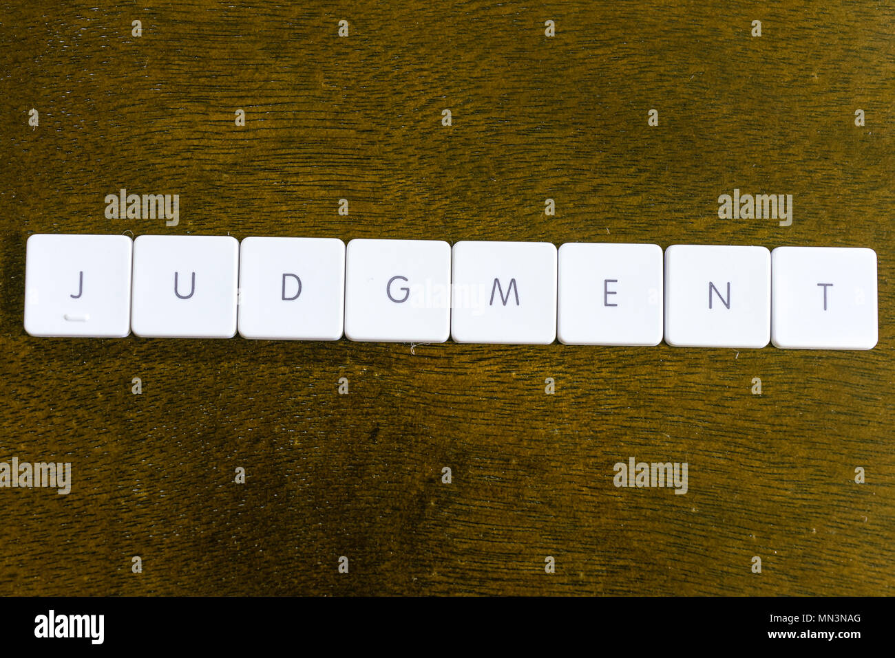 JUDGMENT word written on plastic keyboard alphabet with dark background ...