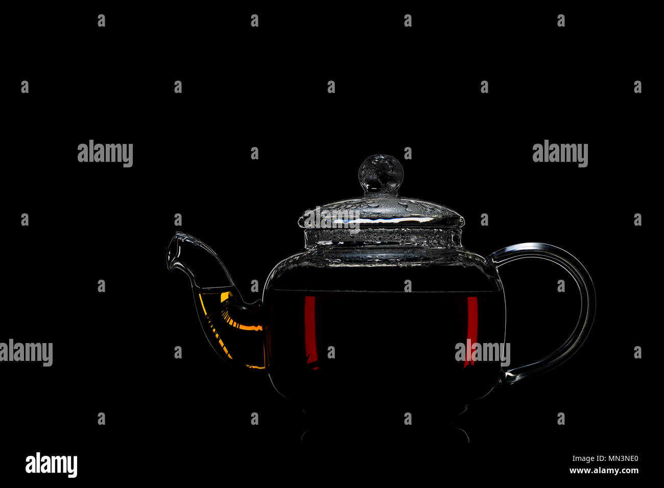 Tea in a transparent teapot on a black background, studio light Stock ...