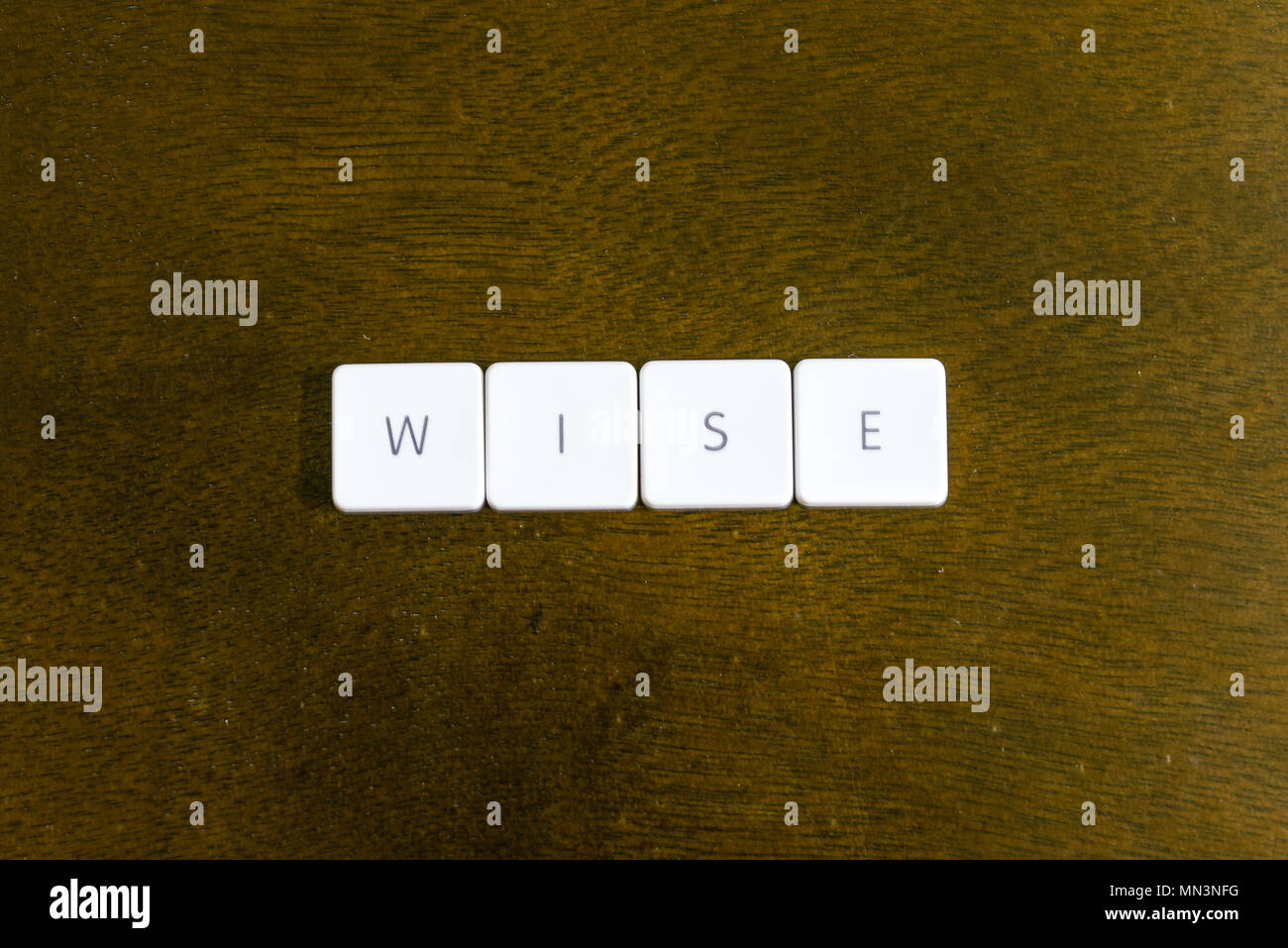 WISE word written on plastic keyboard alphabet with dark background ...