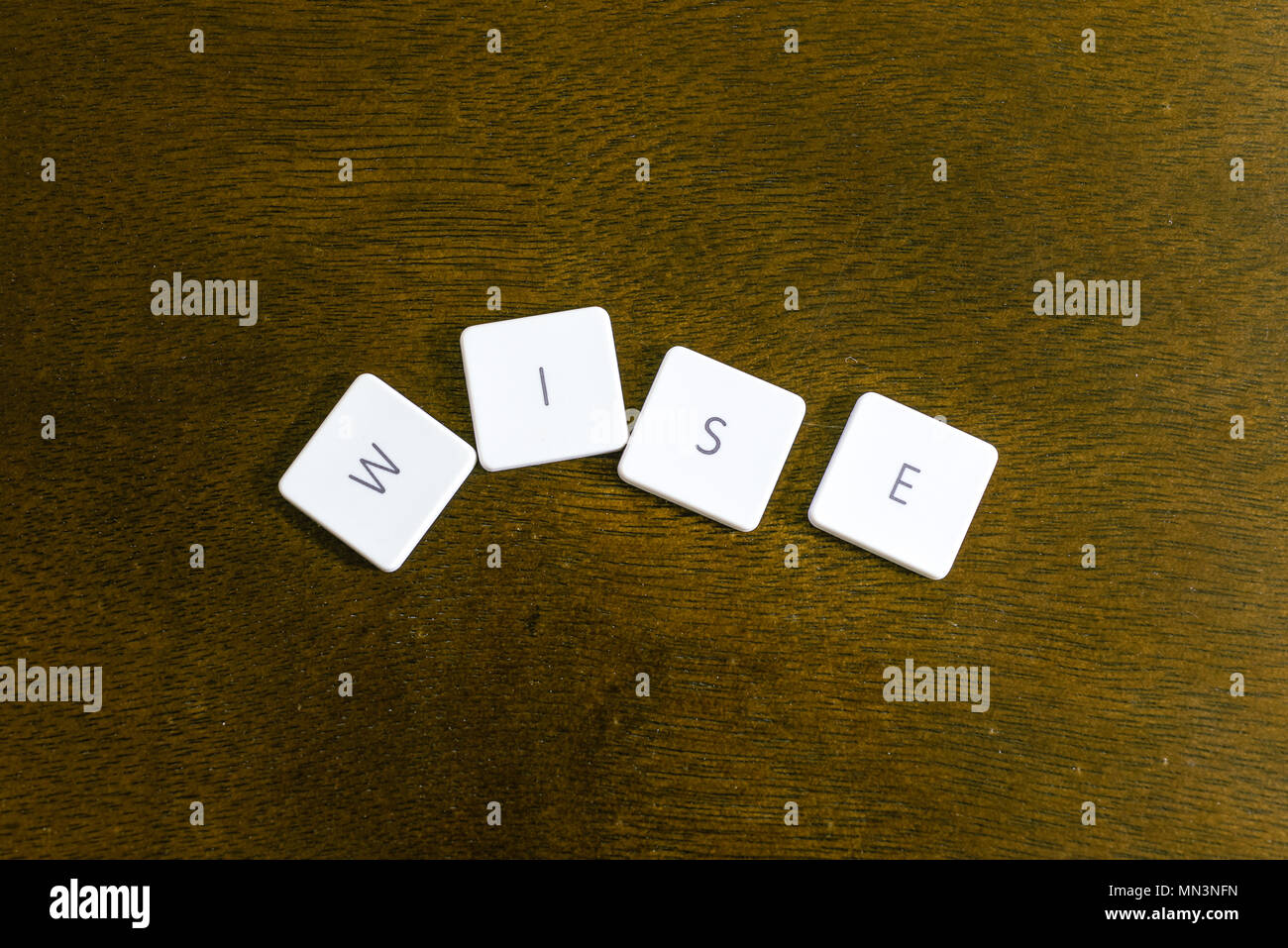 WISE word written on plastic keyboard alphabet with dark background ...