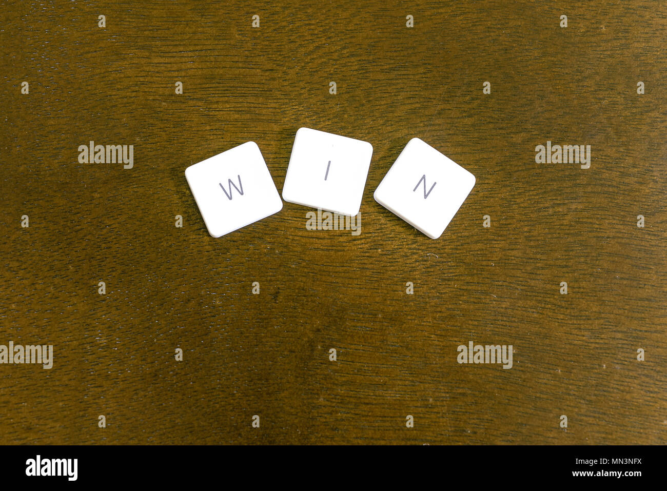 WIN word written on plastic keyboard alphabet with dark background ...