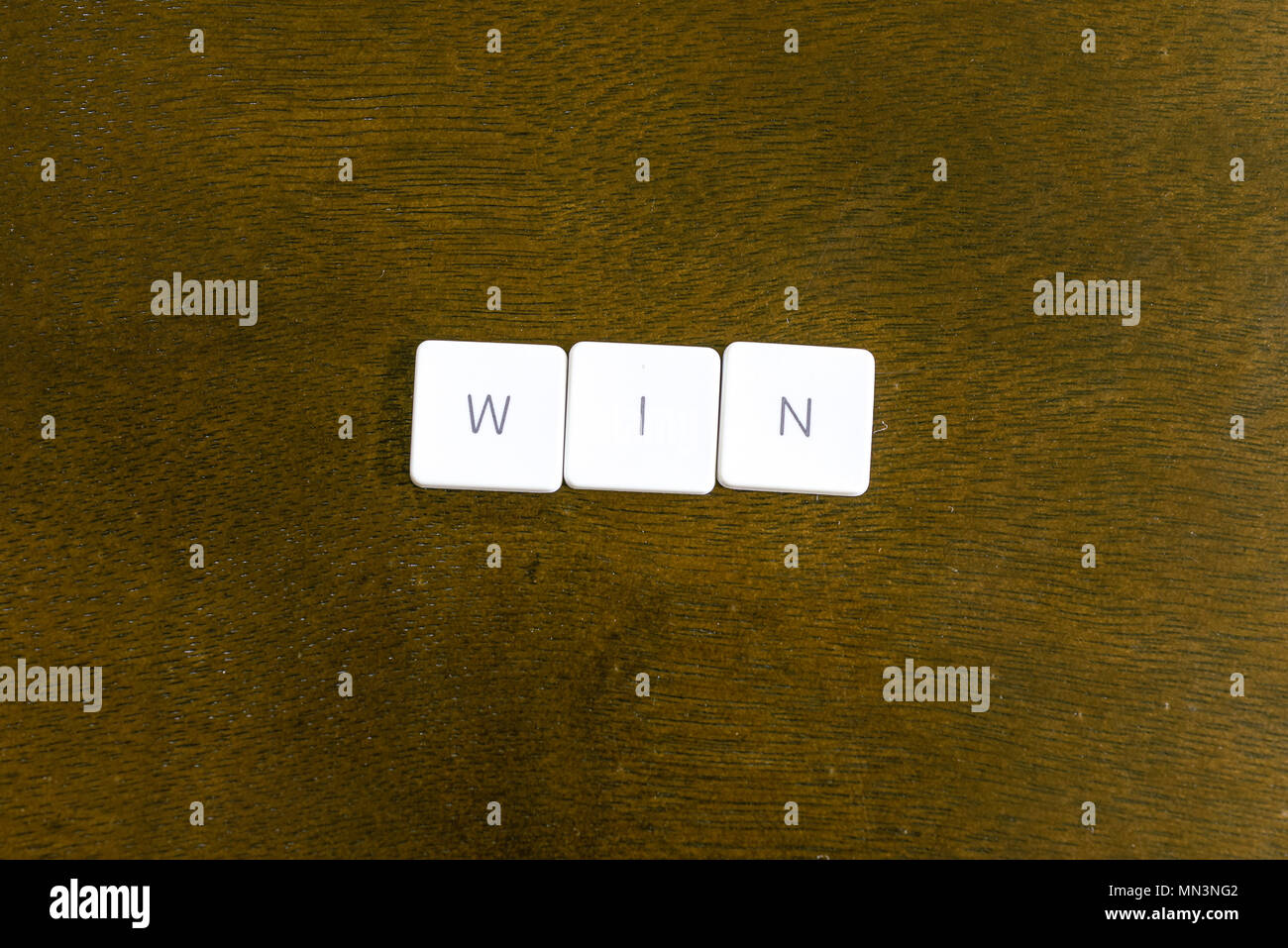 WIN word written on plastic keyboard alphabet with dark background ...