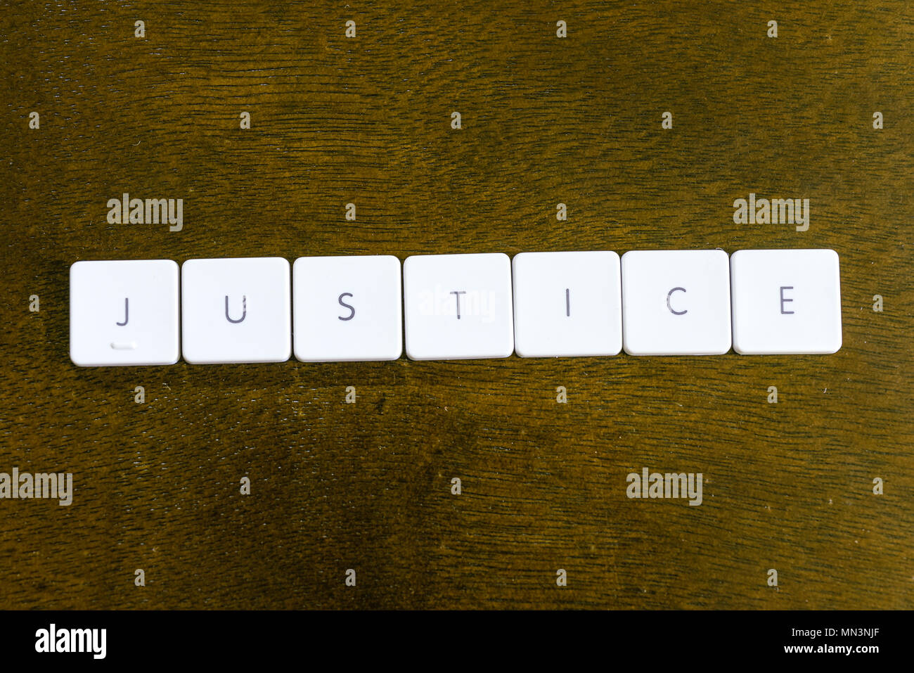 JUSTICE word written on plastic keyboard alphabet with dark background ...