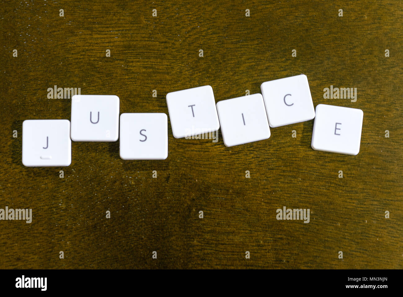JUSTICE word written on plastic keyboard alphabet with dark background ...