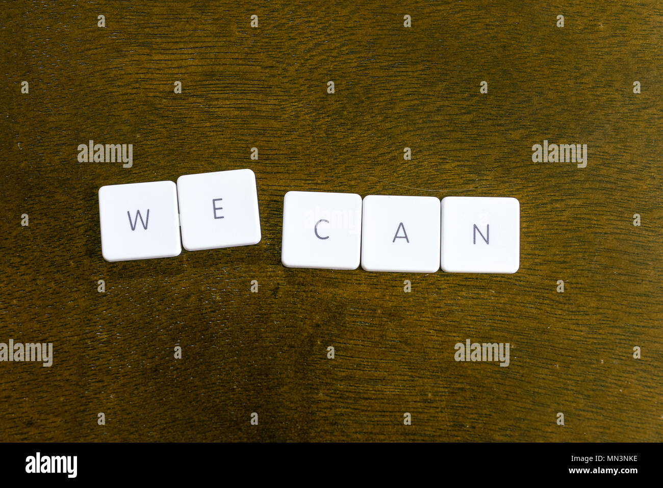 WE CAN word written on plastic keyboard alphabet with dark background ...