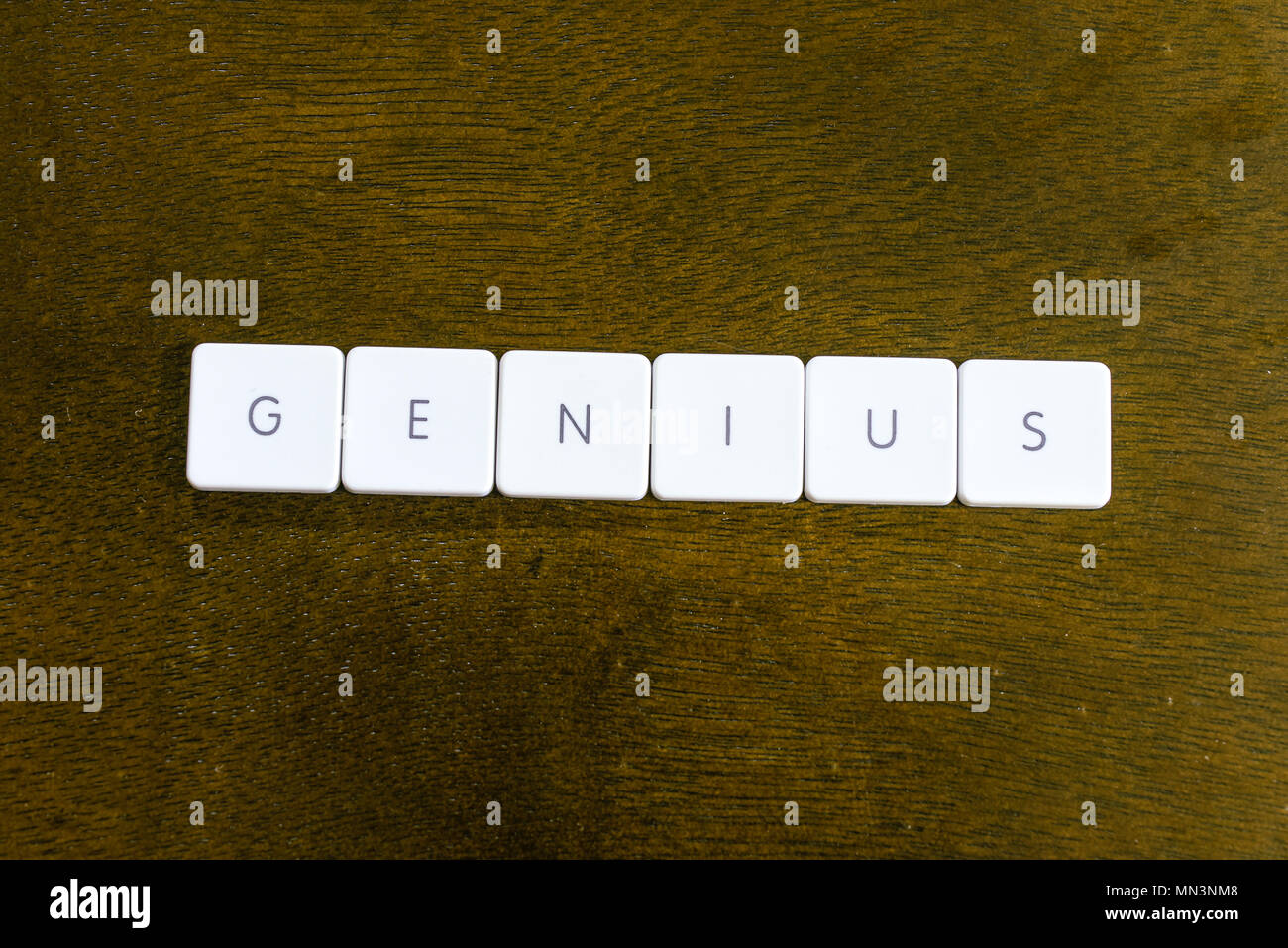 GENIUS word written on plastic keyboard alphabet with dark background ...