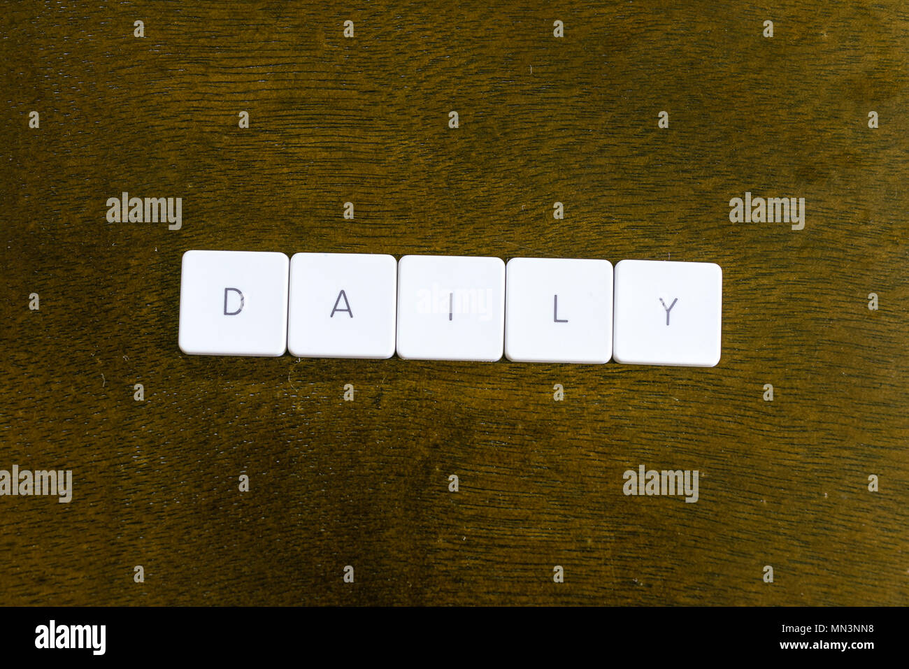 DAILY word written on plastic keyboard alphabet with dark background ...