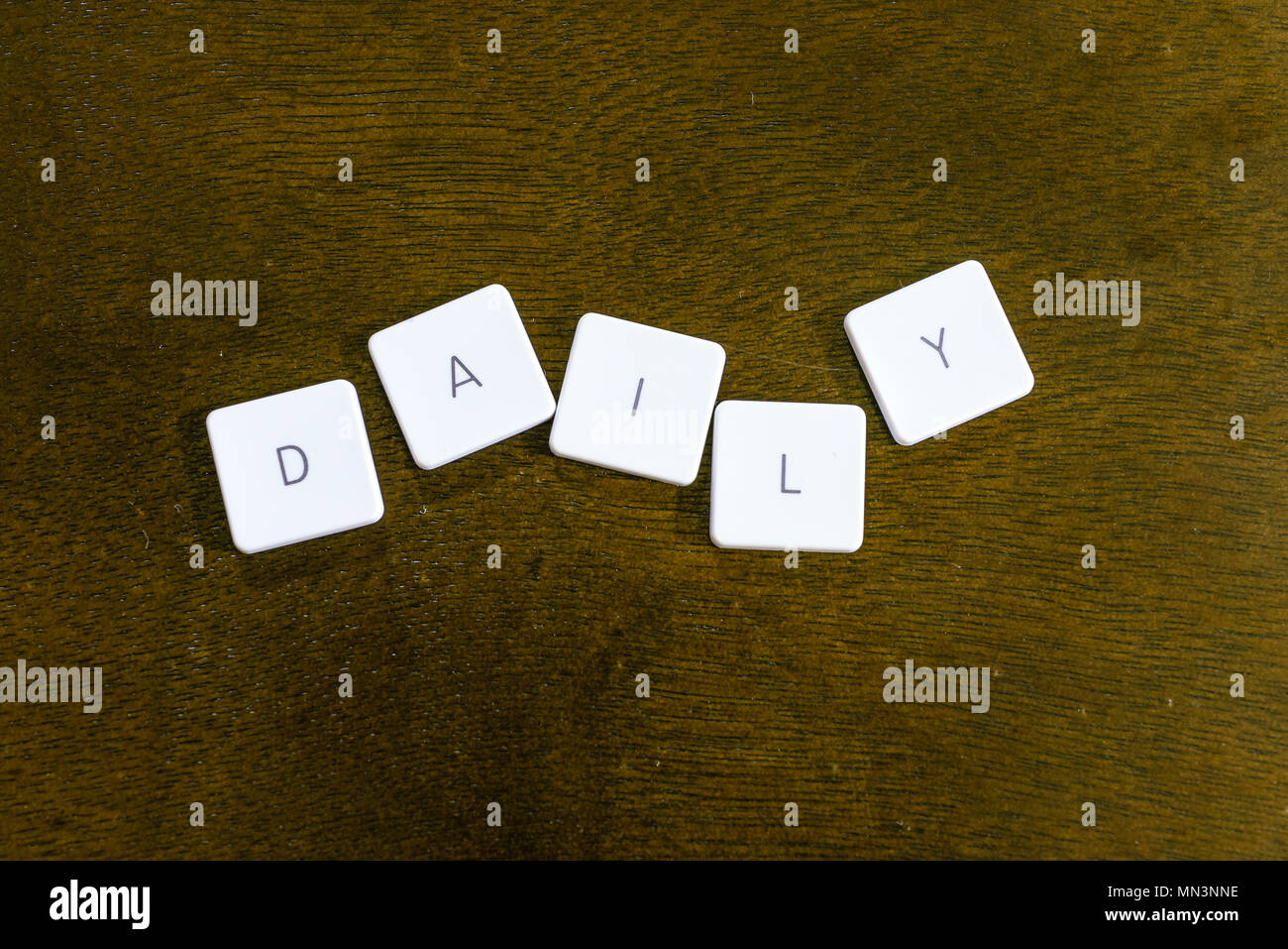 DAILY word written on plastic keyboard alphabet with dark background ...