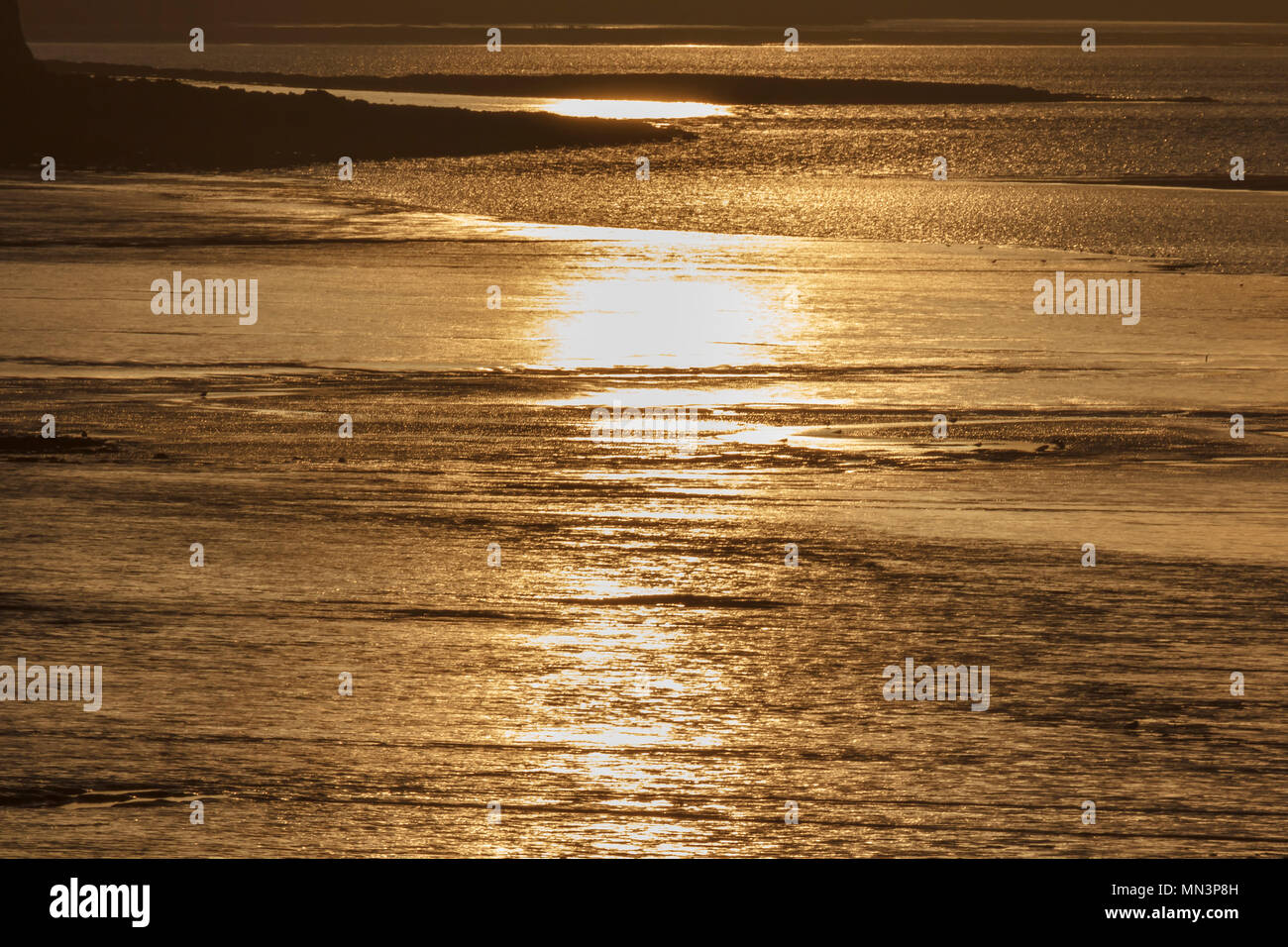 Sunset with sunlight reflecting onto the Mud Stock Photo - Alamy