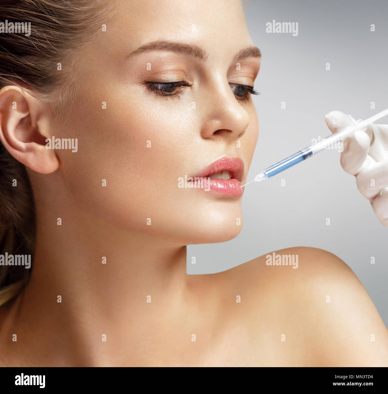 Beautiful woman face and beautician hands with syringe makes cosmetic ...