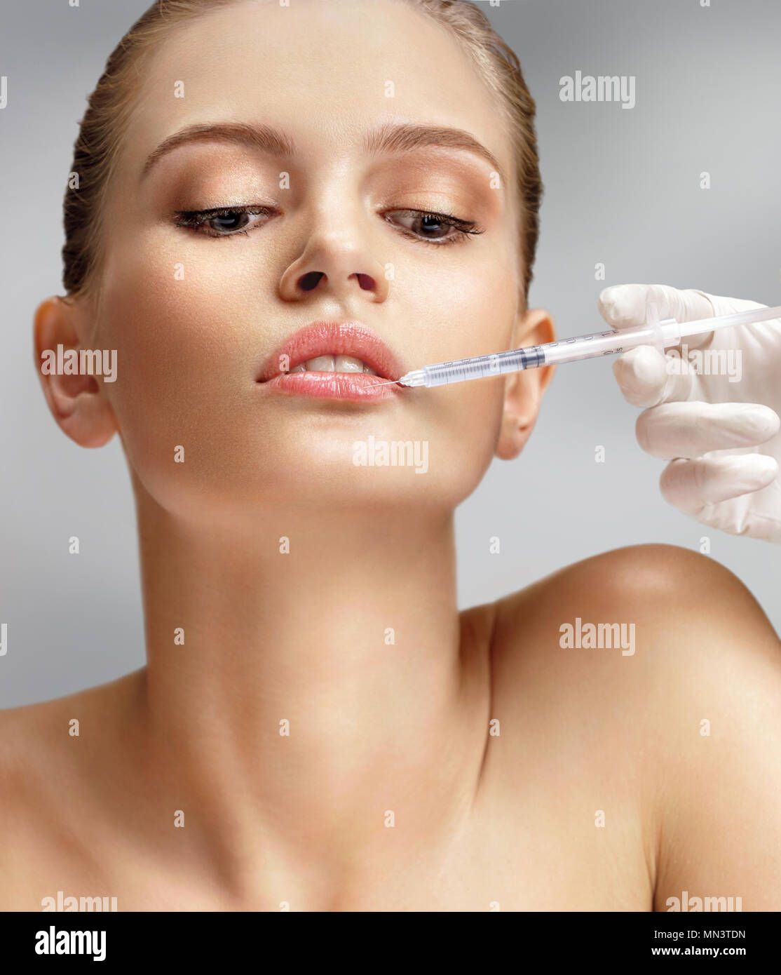 Beautiful woman face and beautician hands with syringe makes cosmetic ...