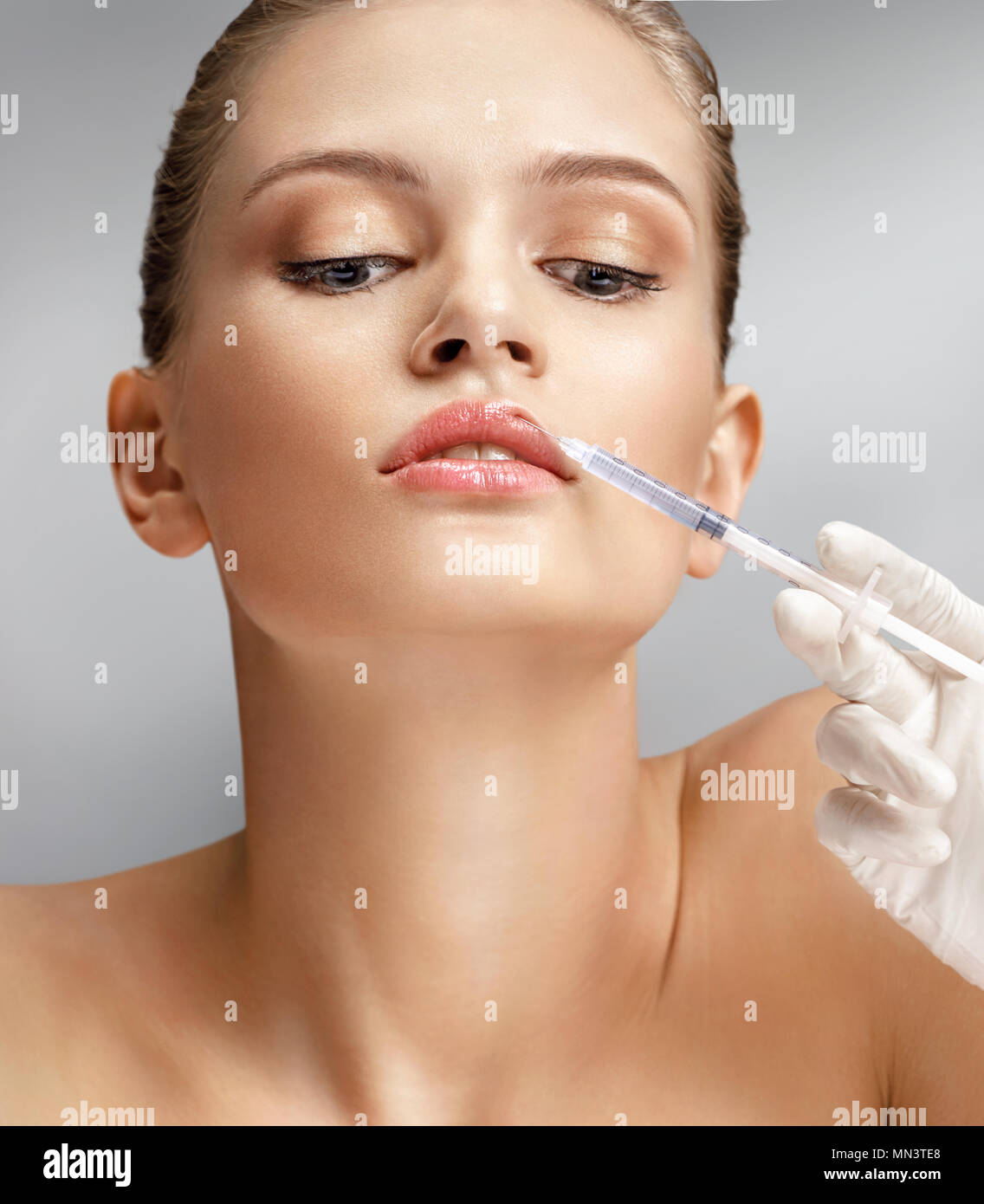Beautiful woman face and beautician hands with syringe makes cosmetic ...