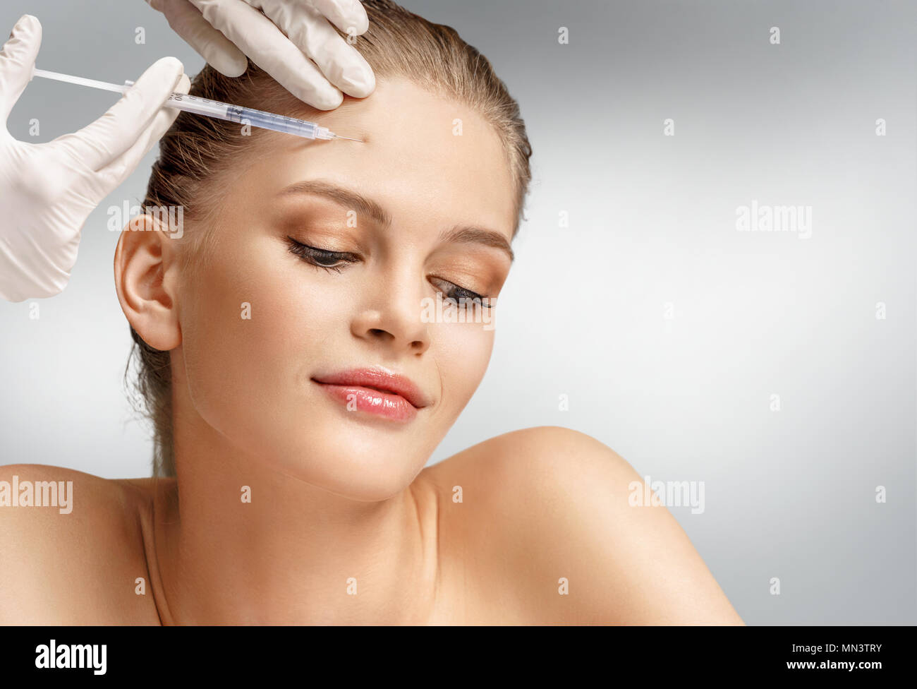 Beautiful woman face and beautician hands with syringe makes cosmetic ...