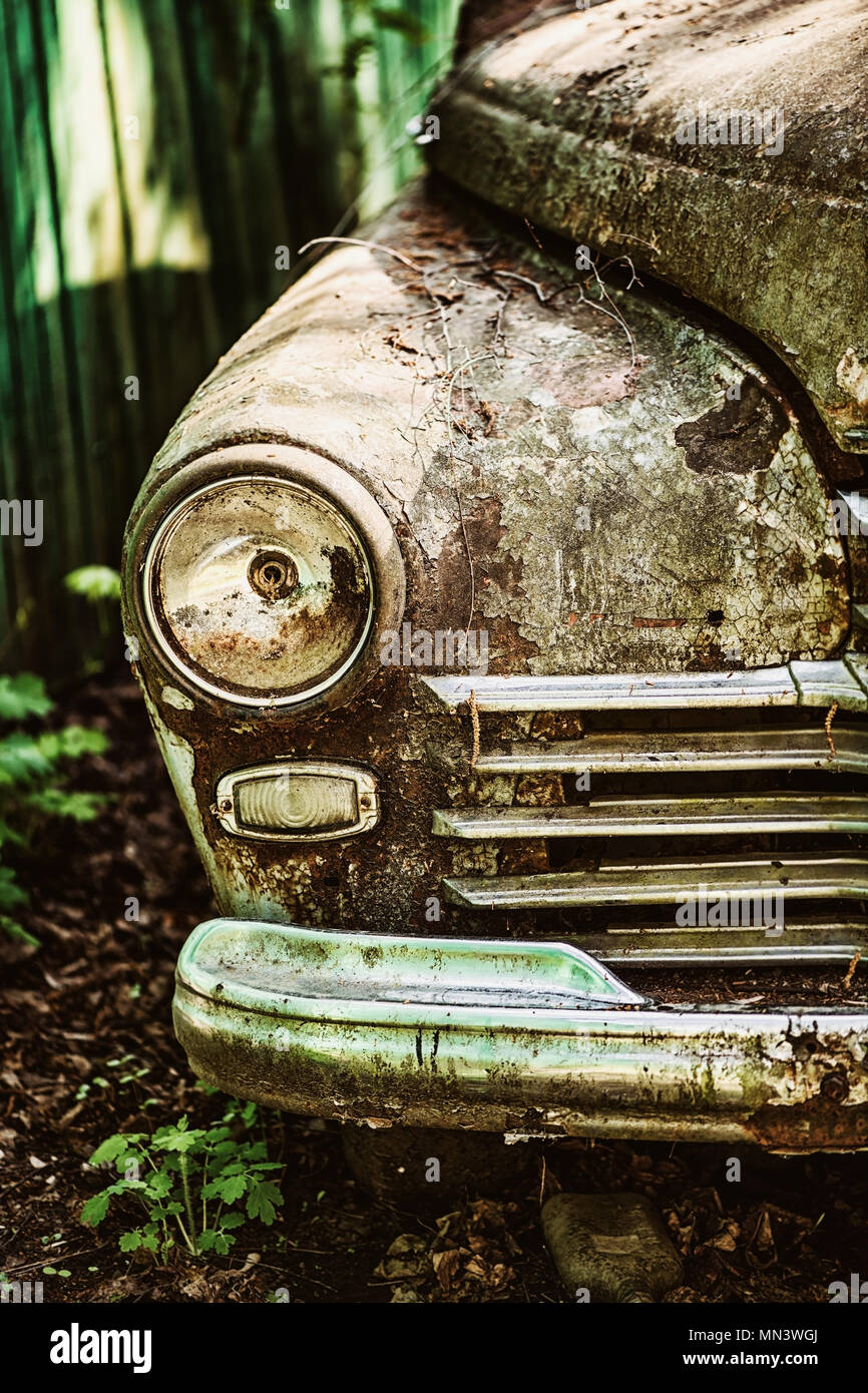 An old rusty abandoned car outdoors in the woods. broken car headlight close-up Stock Photo - Alamy