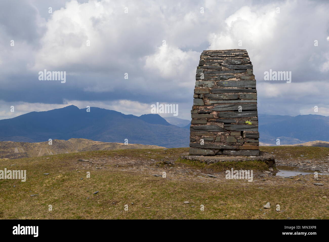A dark and shadowy Snowdon can be seen from the Trig Point that stands ...
