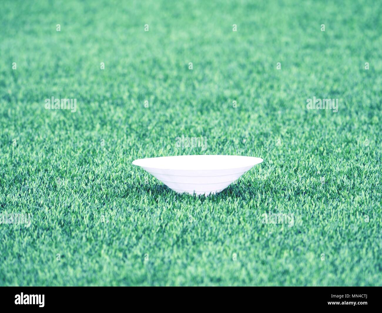 Training cone for football on a green field. Artificial green turf ...