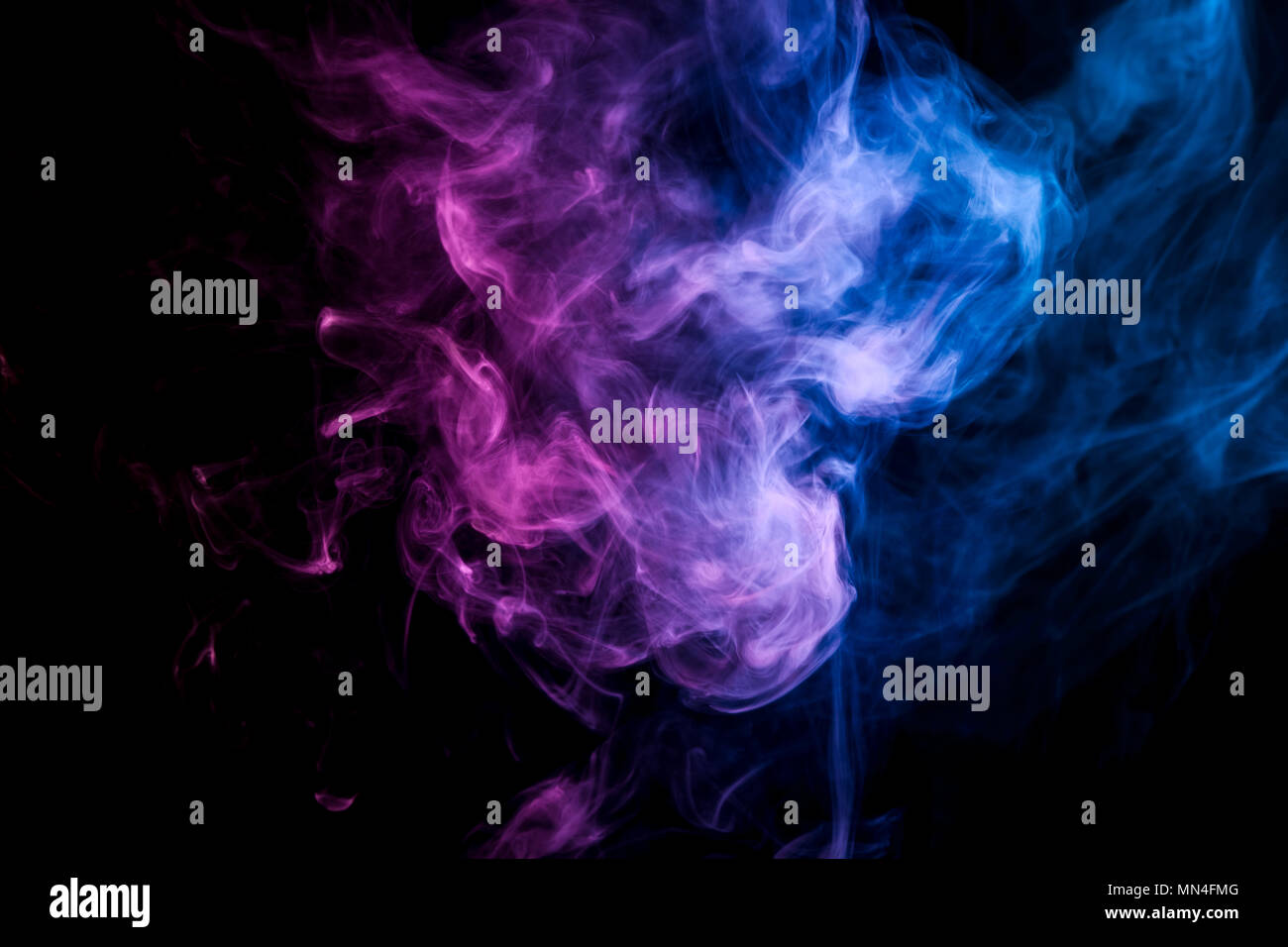 Dense multicolored smoke of blue and pink colors on a black isolated ...