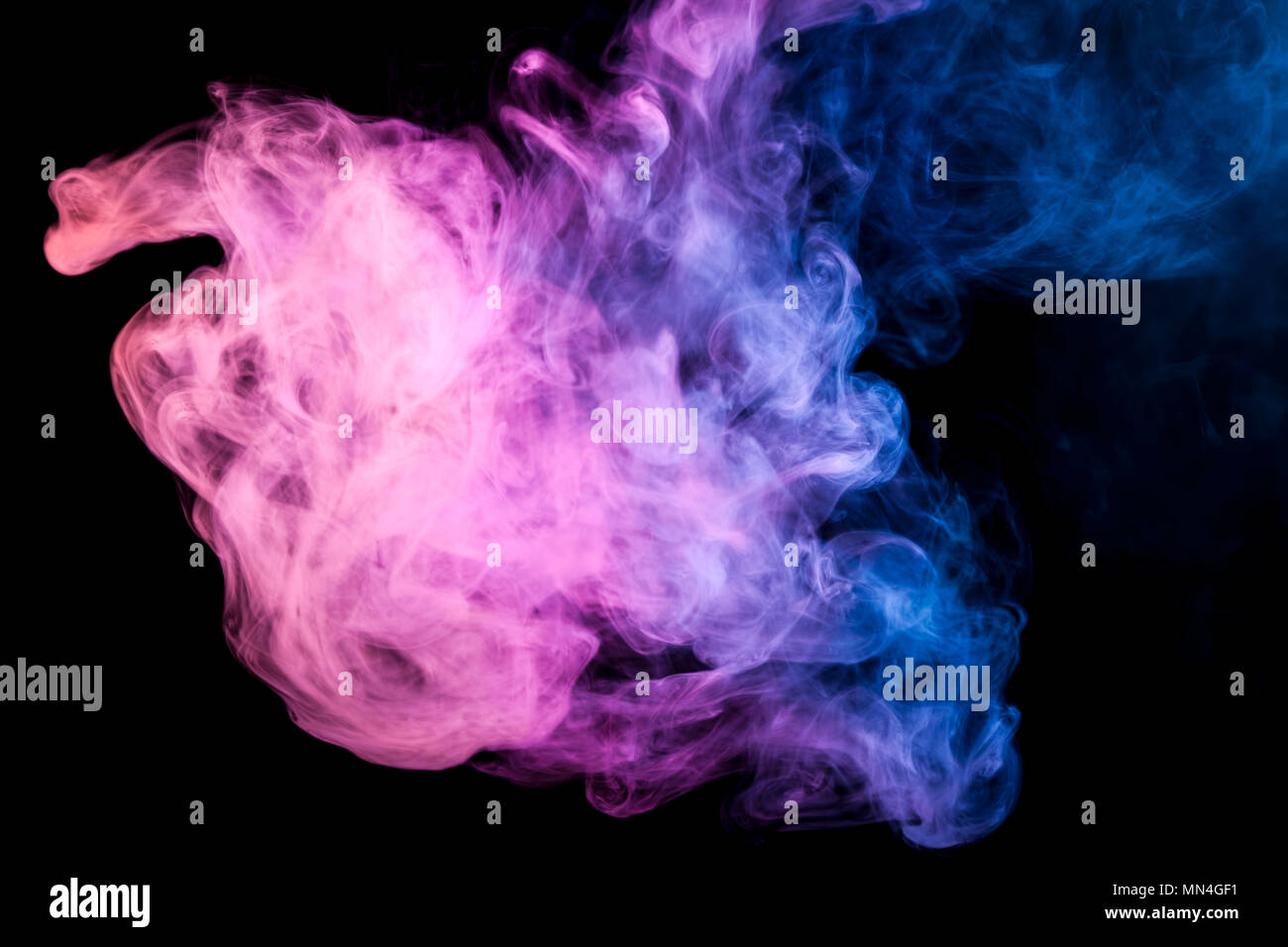 Dense multicolored smoke of blue and pink colors on a black isolated ...