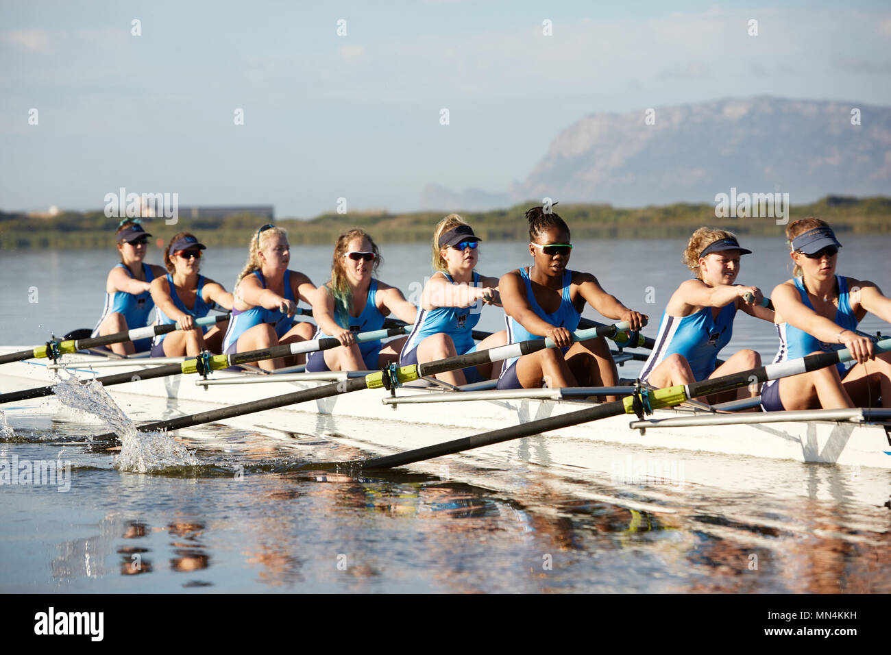 Female rowers rowing scull on sunny lake Stock Photo - Alamy