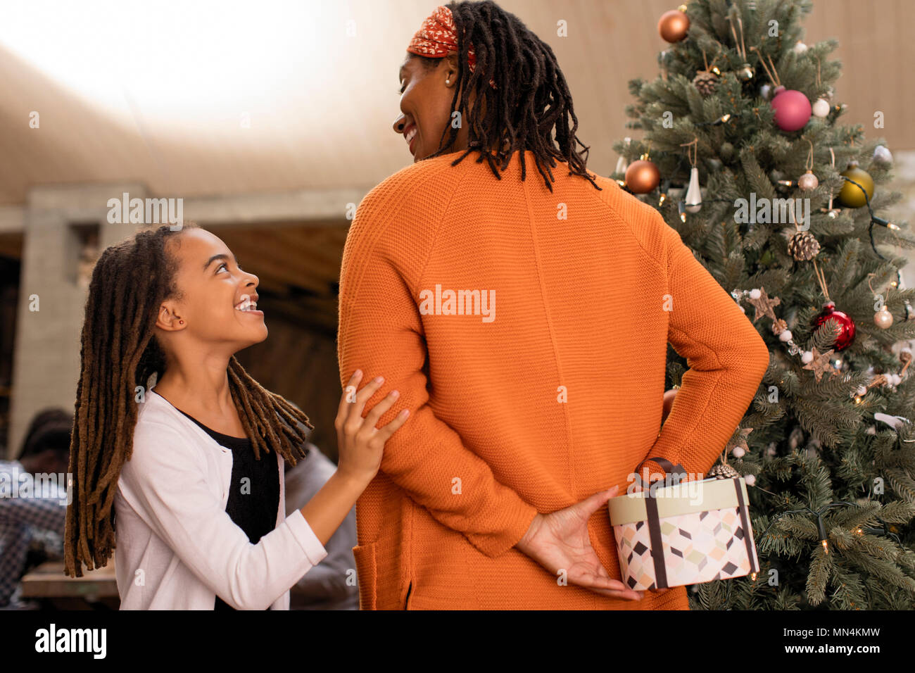 Mother hiding Christmas gift from curious daughter Stock Photo - Alamy