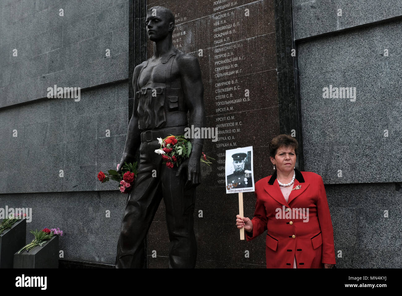 A woman holds a photo of a person who fought in World War II during ...