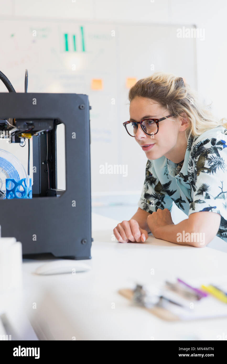Female designer watching 3D printer in office Stock Photo - Alamy
