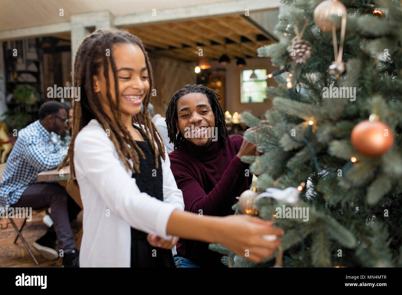 Brother and sister decorating Christmas tree Stock Photo - Alamy