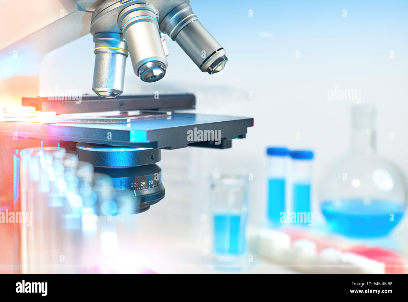 Scientific background with closeup on light microscope and laboratory ...