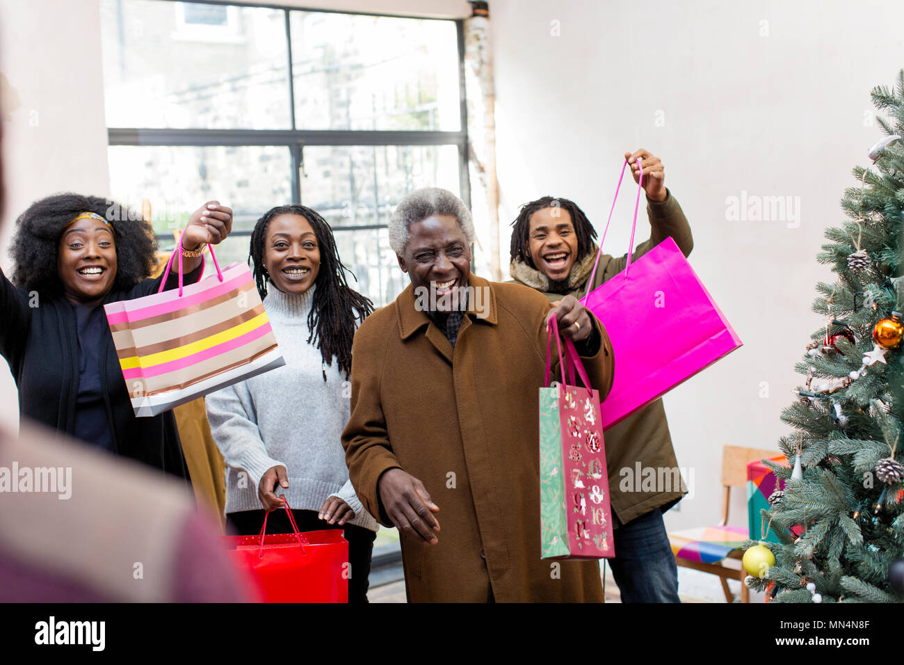 Enthusiastic multi-generation family arriving with Christmas gifts ...