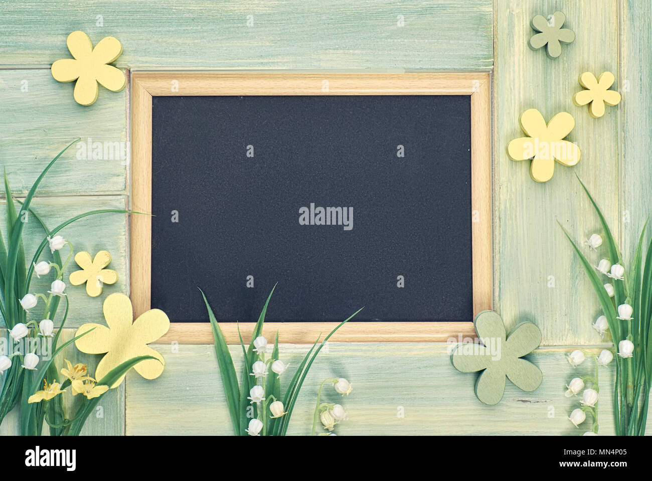 Spring holiday background: blackboard framed with spring flowers on ...