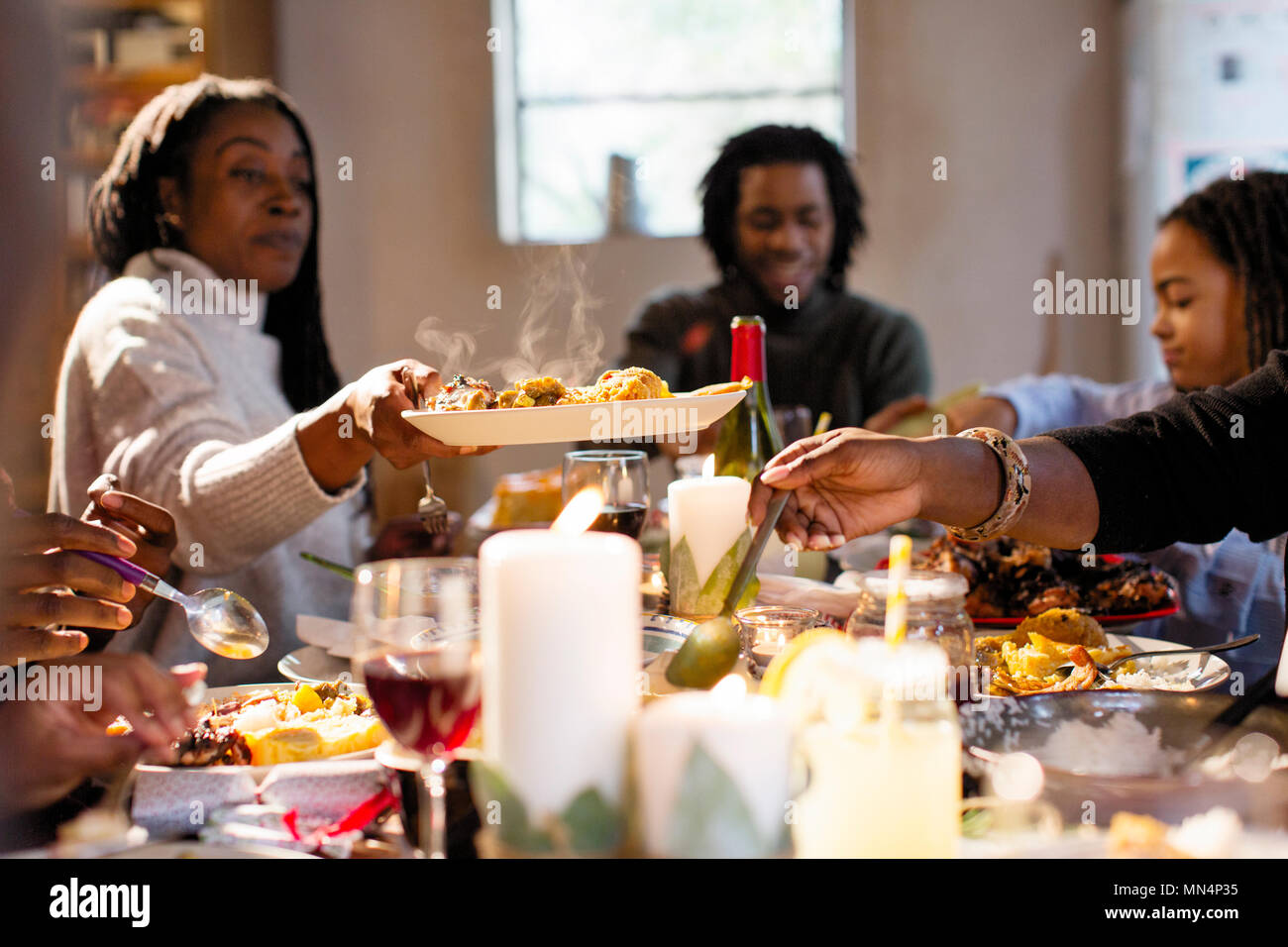 Woman passing food at Christmas dinner Stock Photo - Alamy