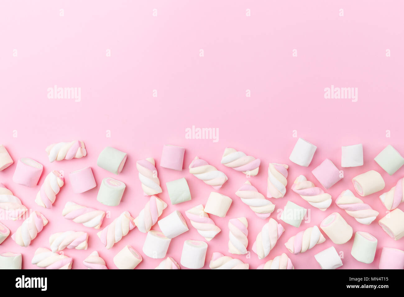 Different pastel color marshmallows on pink pastel background with copy ...