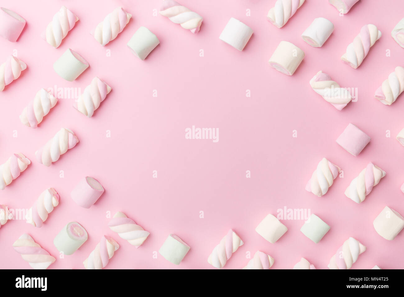 Different pastel color marshmallows on pink pastel background with copy ...