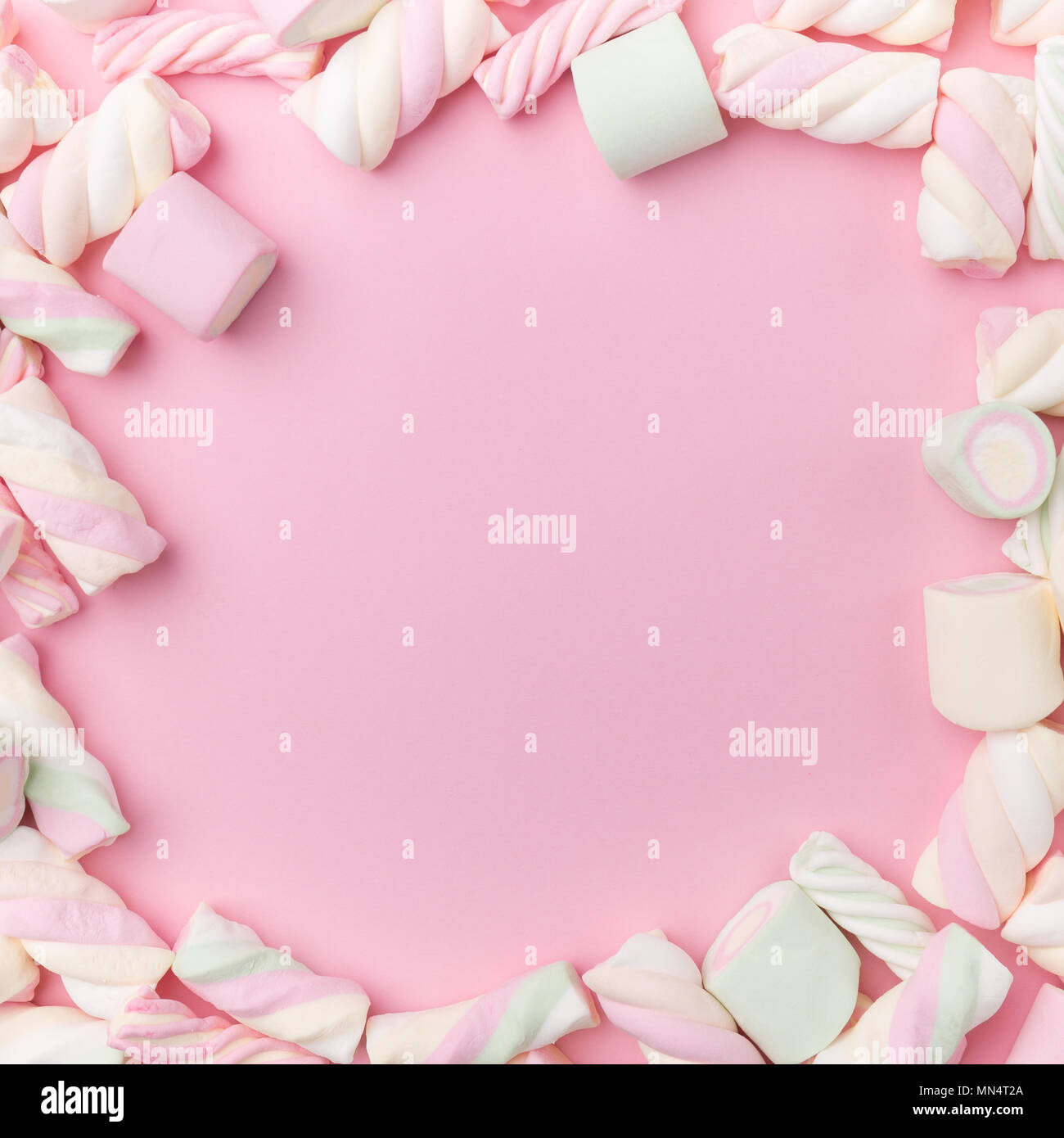 Different pastel color marshmallows on pink pastel background with copy ...