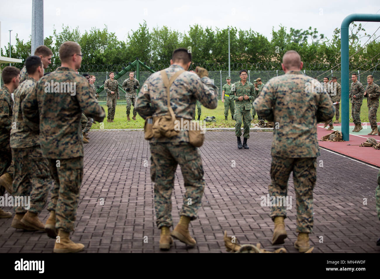 A Singapore Armed Forces Soldier leads U.S. Marines and Sailors in warm ...